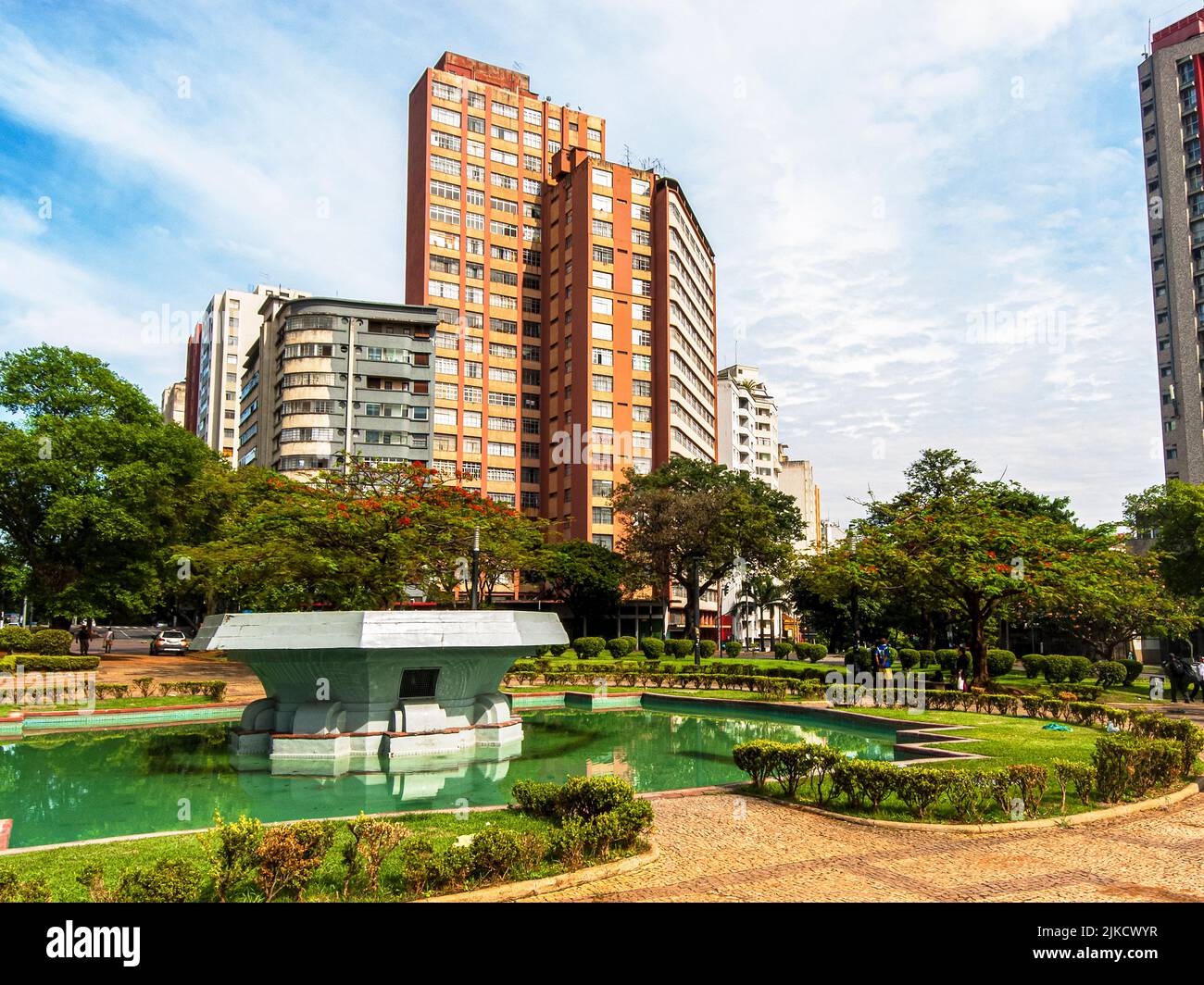 Trees, fountain, blue sky and beautiful residential and commercial ...