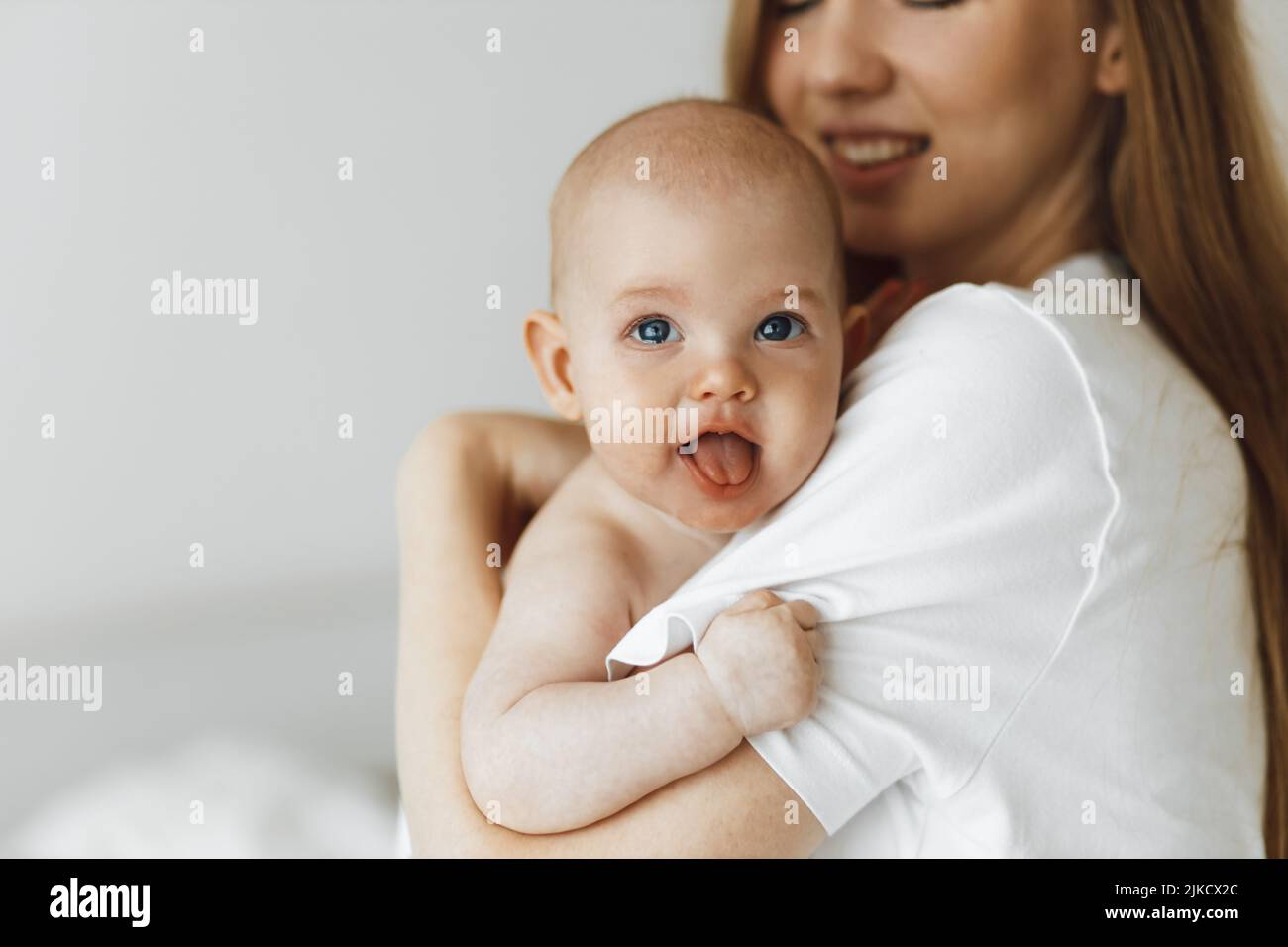 young caring mother hugged her little daughter, pressing her to her ...