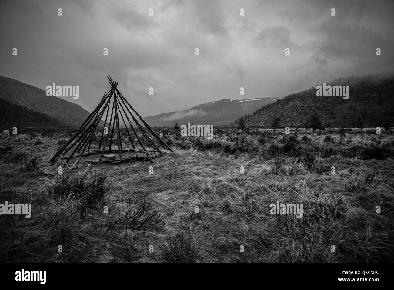 A grayscale shot of a nomadic tribe teepee structure on a rural field ...