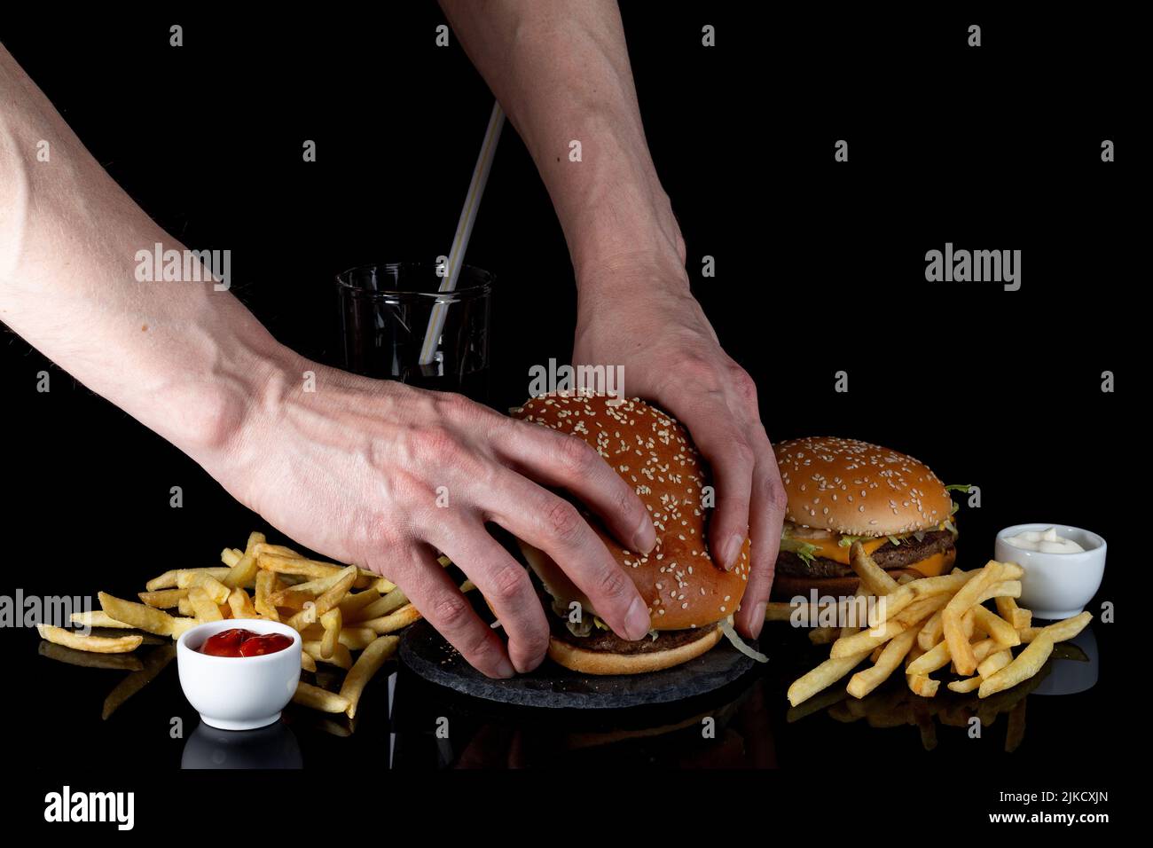 fresh tasty hamburger, french fries, cola on black glass with ...