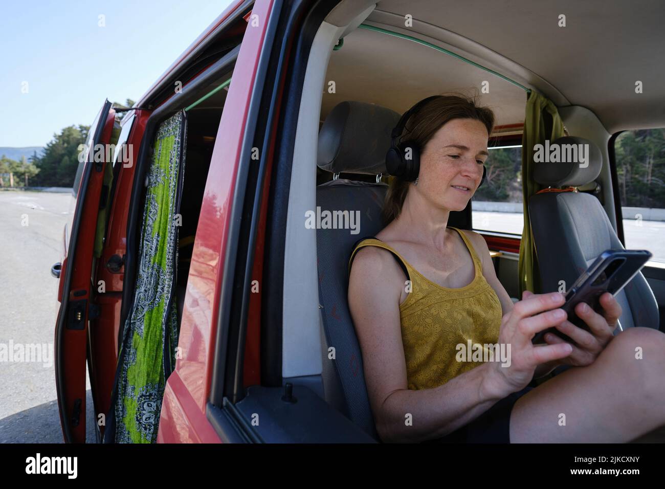 Woman browsing smartphone and listening to music in car Stock Photo - Alamy