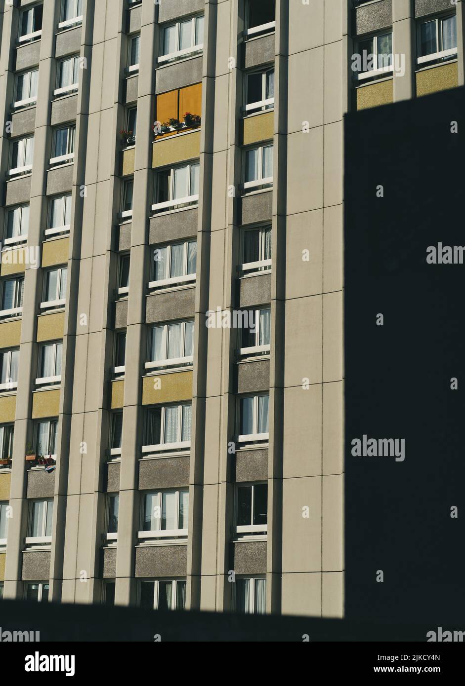 A vertical shot of a high rise building with light beige walls and wide ...