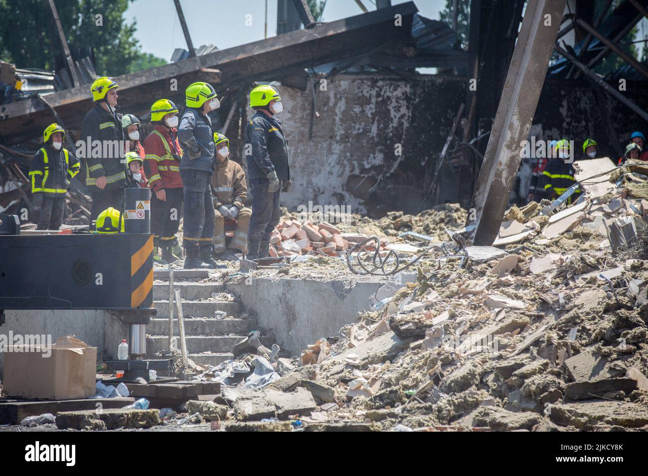 Rescuers work to take away debris at a shopping mall burned after a ...