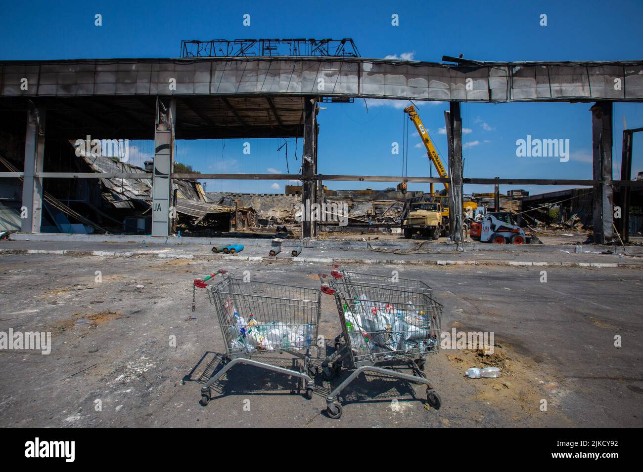 Grocery carts stand outside a shopping mall burned after a rocket ...