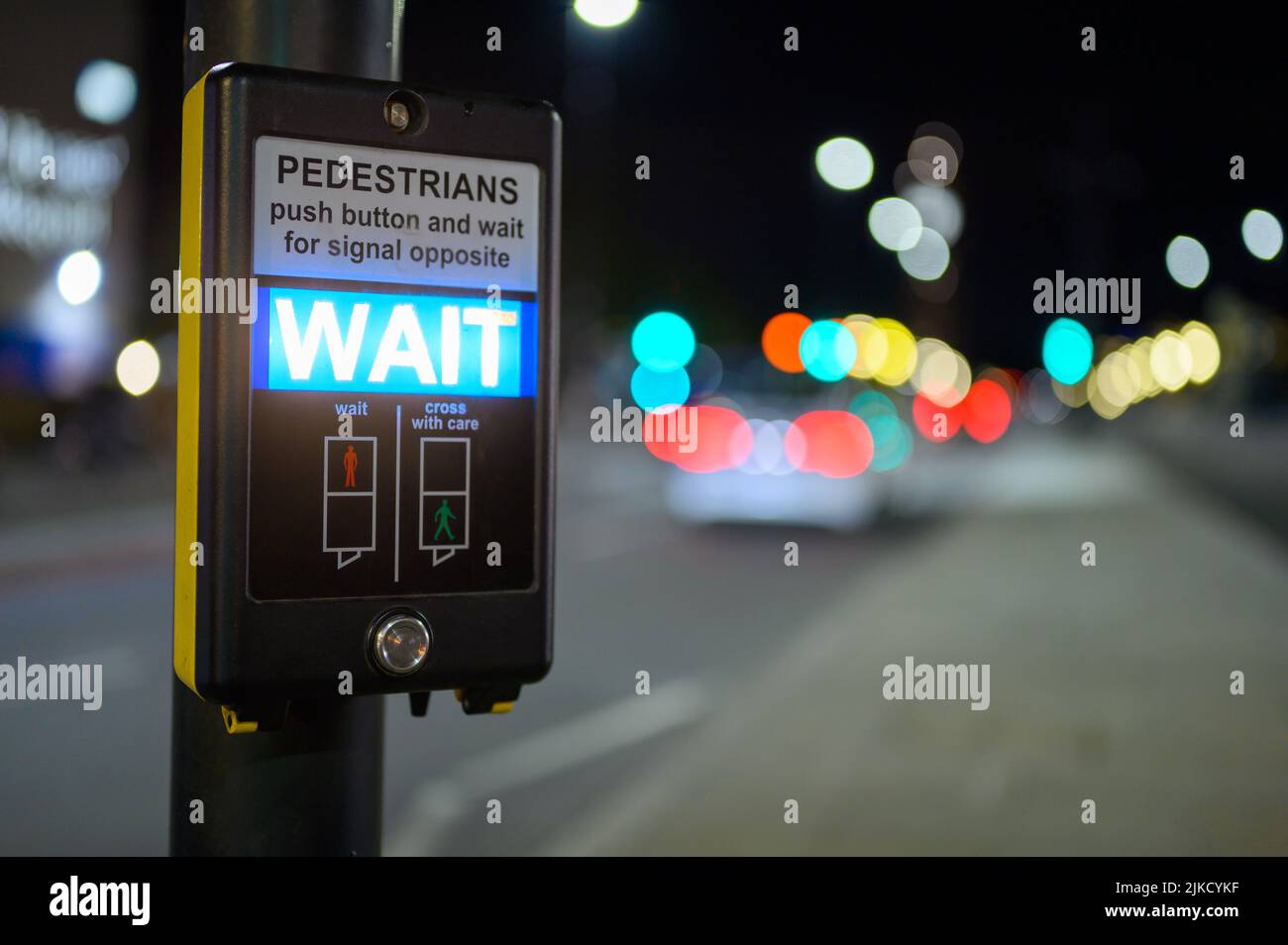 Pedestrian crossing button and illuminated wait sign with out of focus ...