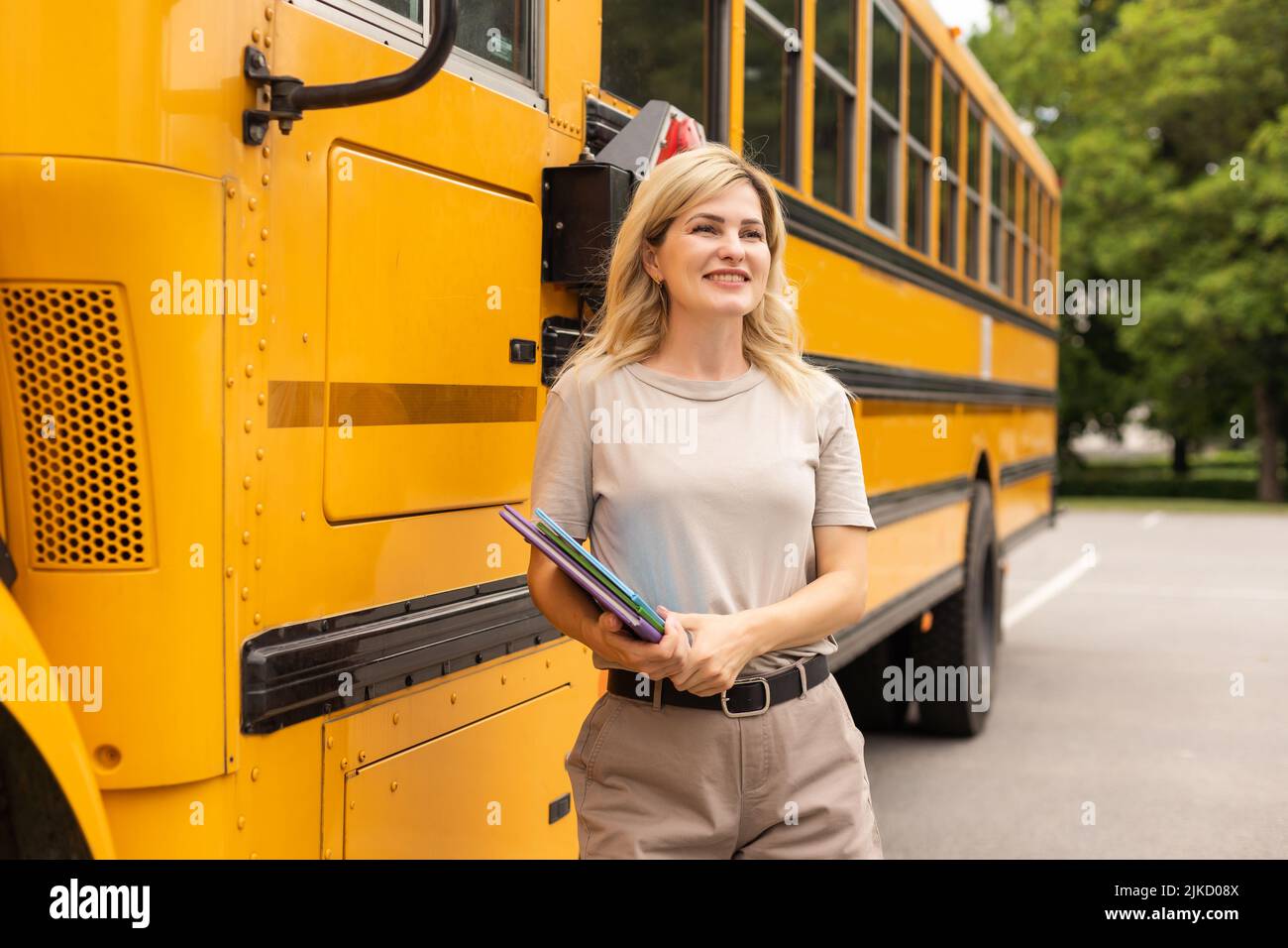 Teacher of elementary school near the school bus Stock Photo - Alamy