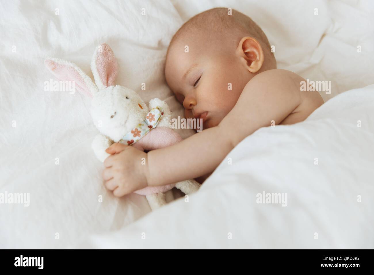Sleeping little baby with favorite soft toy in hand. Carefree sleep of ...