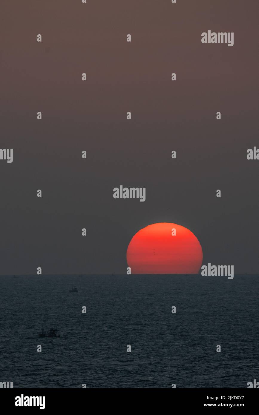 A vertical shot of a beautiful mirage sunset on the sea Stock Photo - Alamy