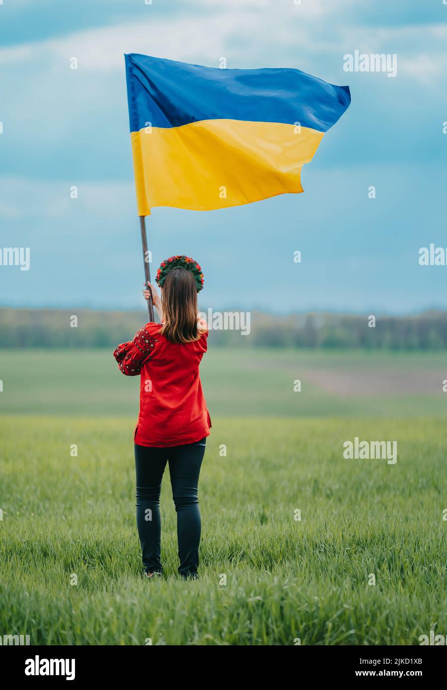 Beautiful ukrainian woman with national flag on green field background ...
