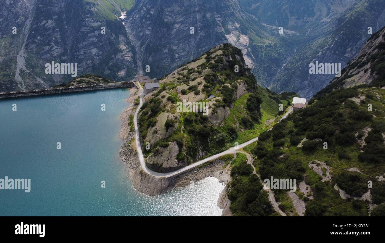 An aerial view of a blue dam in the mountains of Guttannen, Switzerland ...