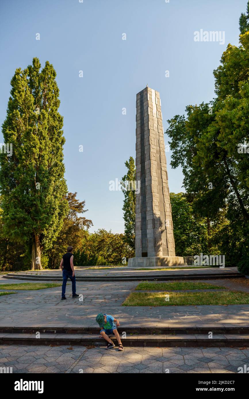 The memorial of war heroes with a walking person and sitting child in ...