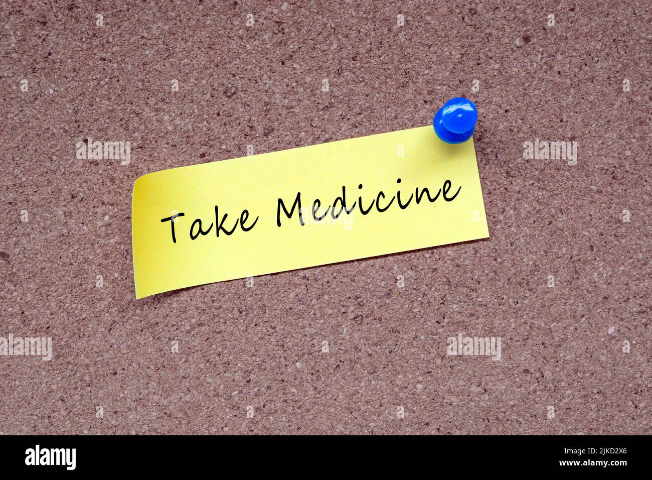 Take medicine words on stick note and pinned to a cork notice board ...