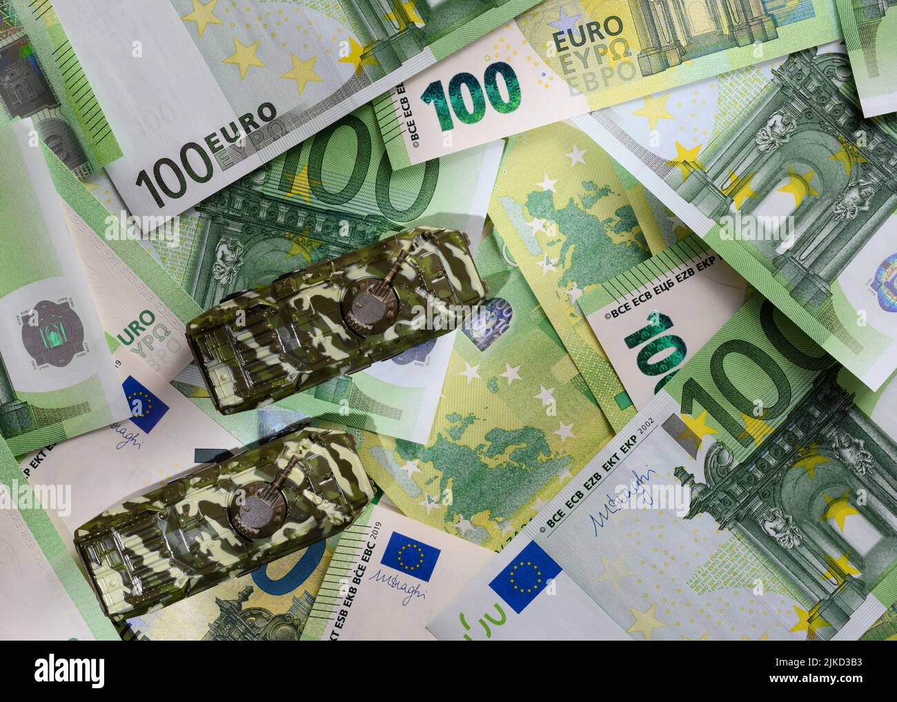 Toy military tanks on the background of 100 Euro banknotes arranged in ...