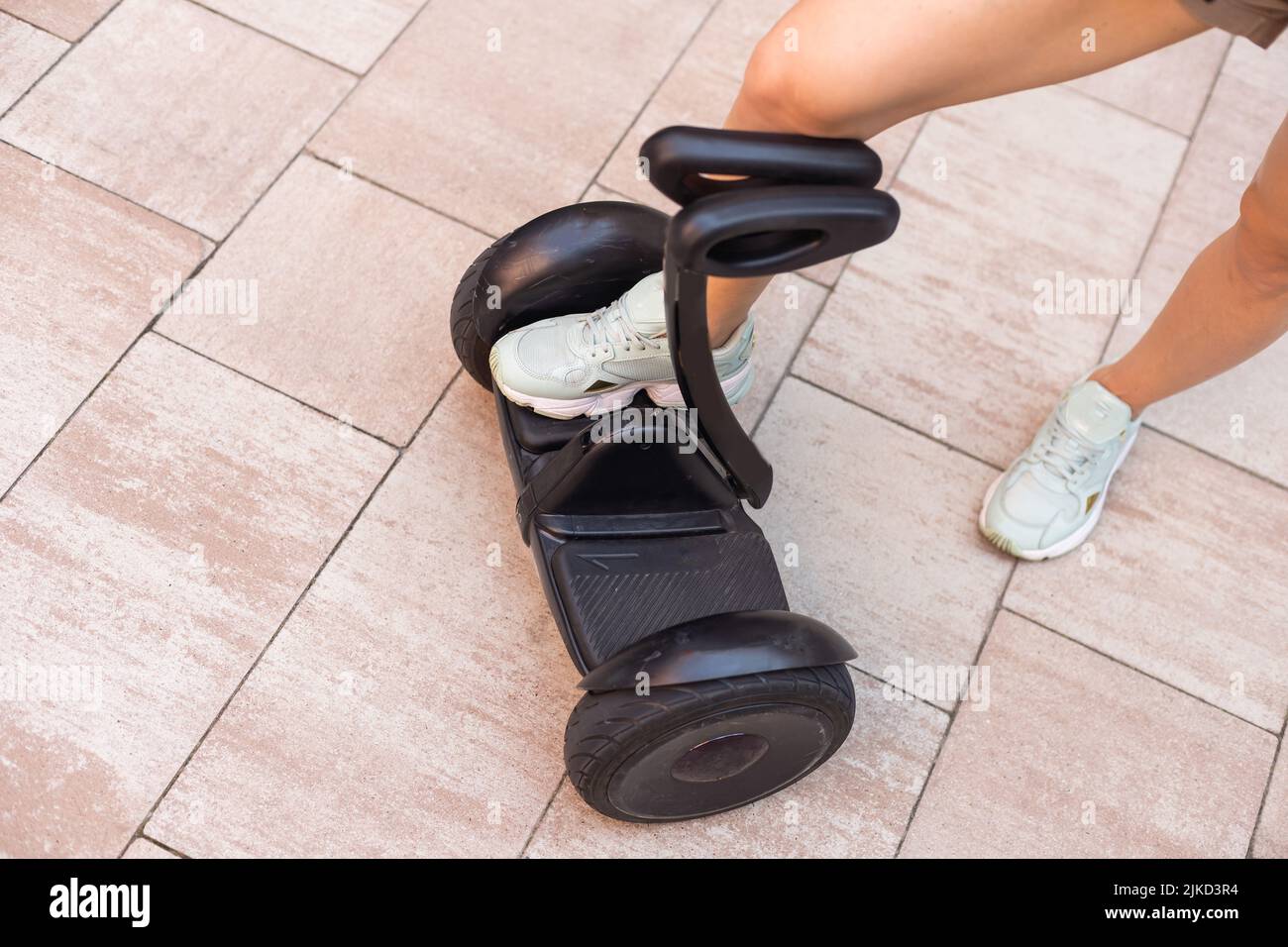 woman riding electric mini segway hover board scooter in green park ...