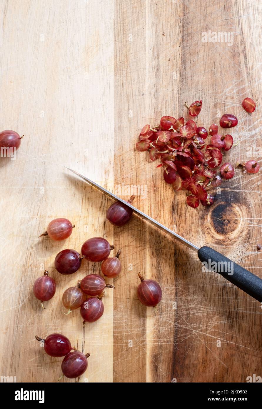 Home cook topping and tailing homegrown Hinnonmaki Red gooseberries on ...