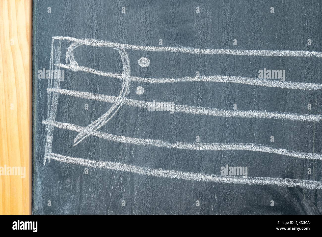 Bass clef hand drawn by a child on a classic traditional chalkboard ...