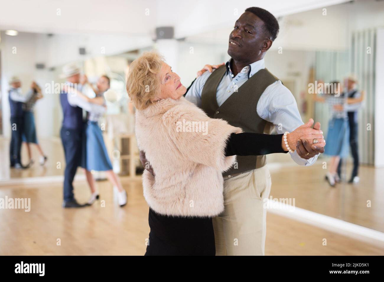 Elderly woman learning ballroom dancing in pair in dance studio Stock ...