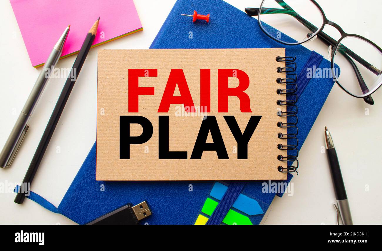The words Play Fair in red text on a yellow sticky note on a green ...