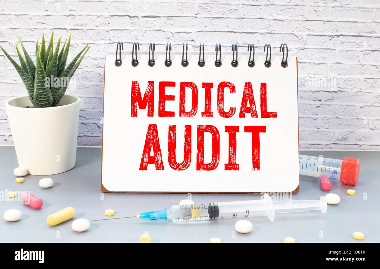 Doctor holding a business card with capital lettering MEDICAL AUDIT in ...