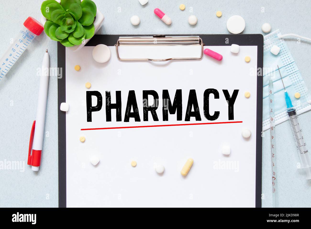 The word PHARMACY is written on notebook near the ampoule on a white ...