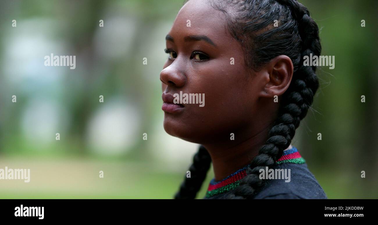 Serious young black woman looking at camera outside. Dramatic African ...