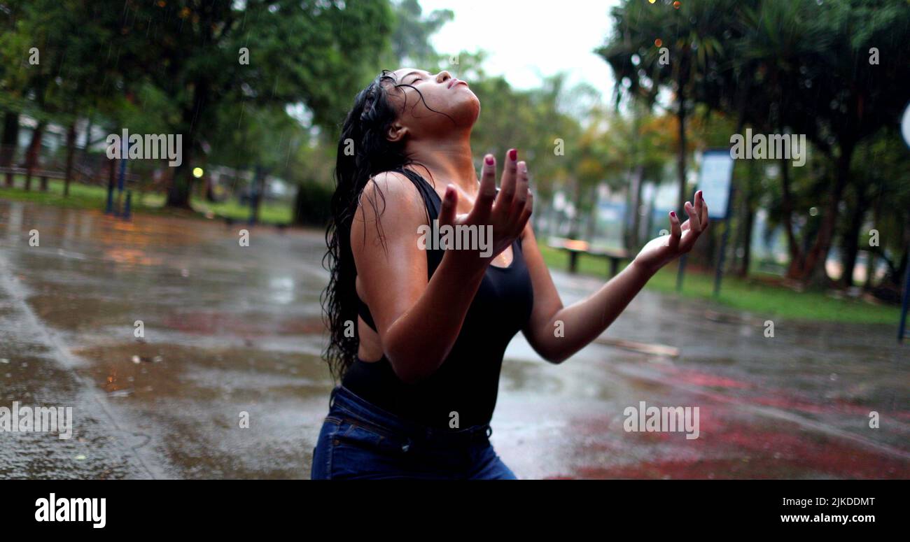 Spiritual young woman in rain shower raising arms, girl raising arms ...