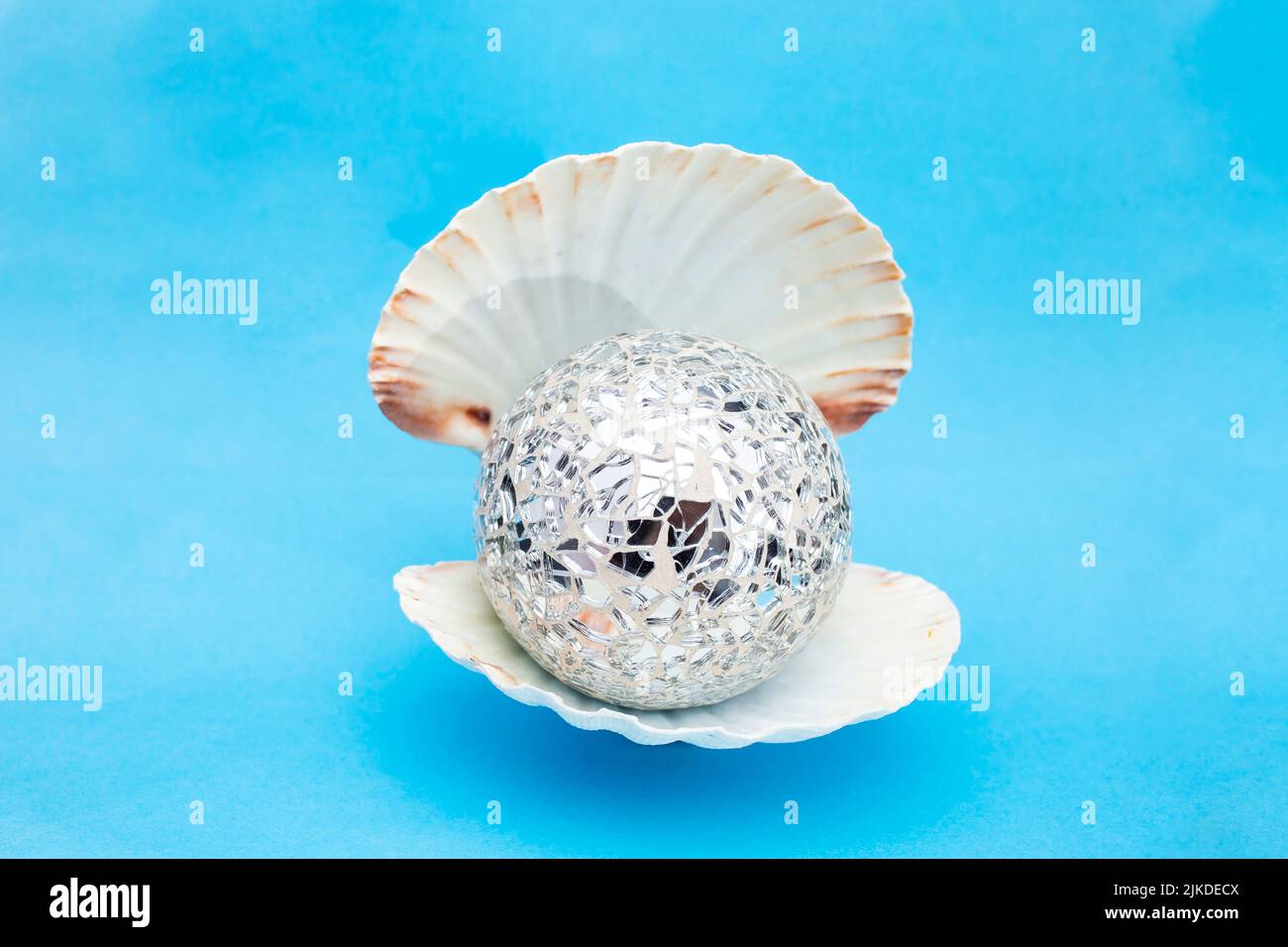 opened sea shell with a mirrors disco ball inside as a pearl, isolated ...