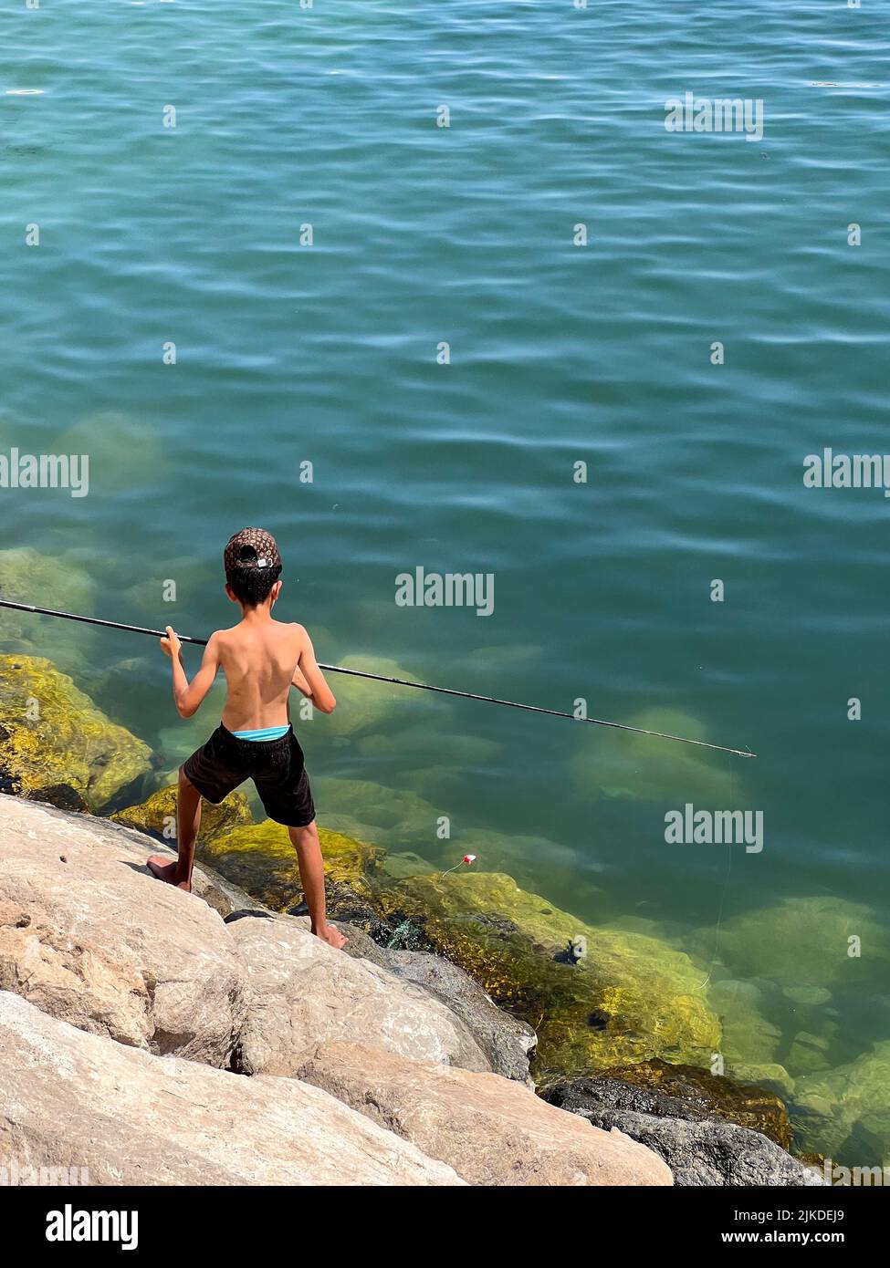 A young boy fishing on the mediterranean sea Stock Photo - Alamy