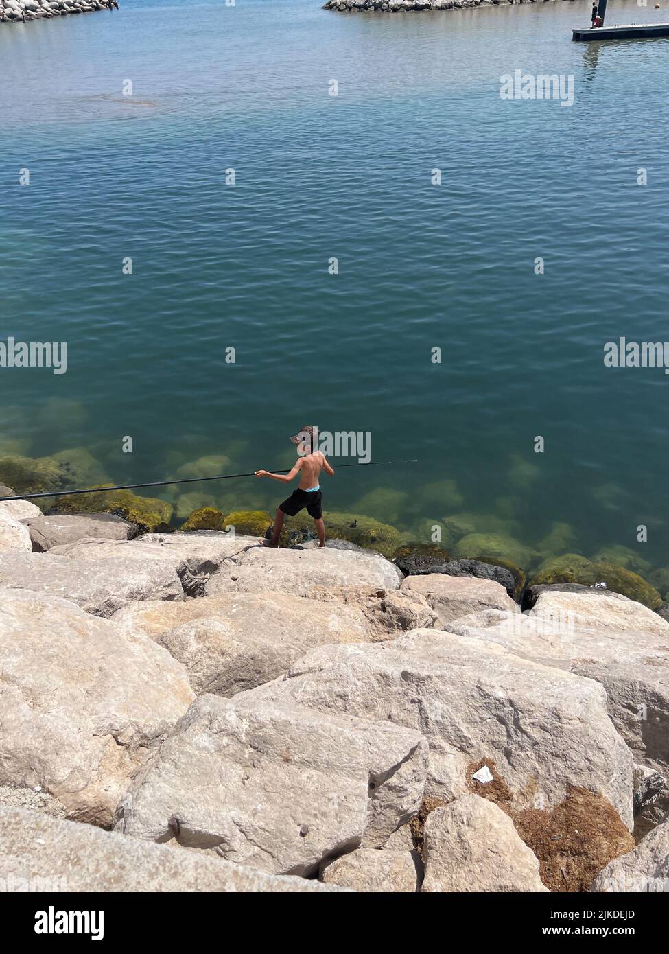 A young boy fishing on the mediterranean sea Stock Photo - Alamy