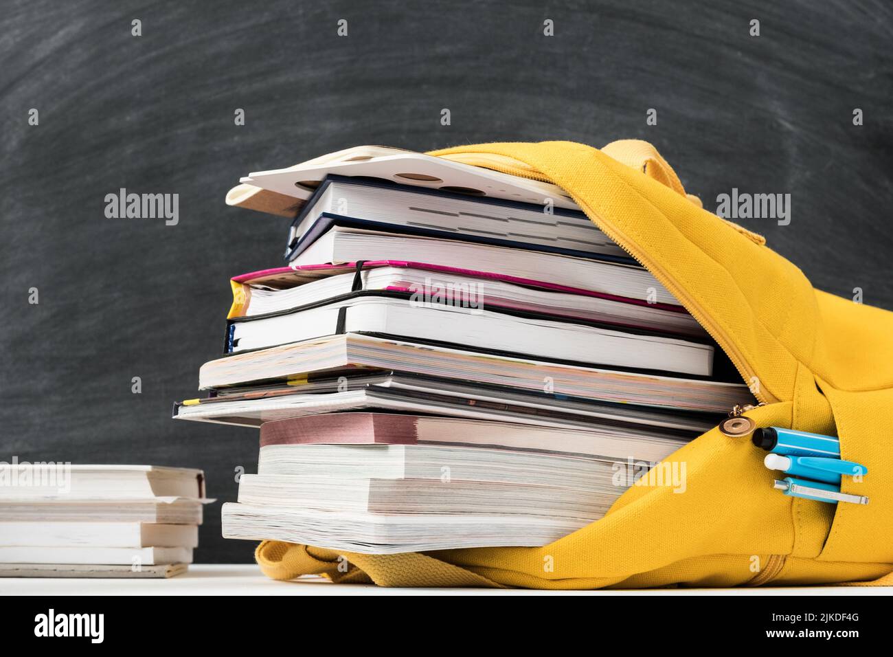 information overload backpack books chalkboard Stock Photo - Alamy