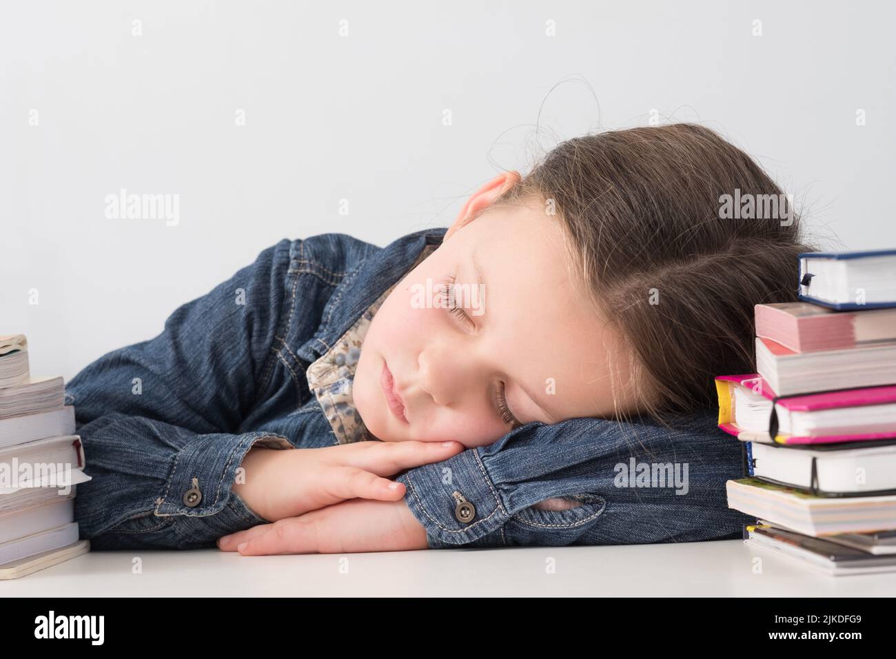school time routine tired kid sleeping book stacks Stock Photo - Alamy