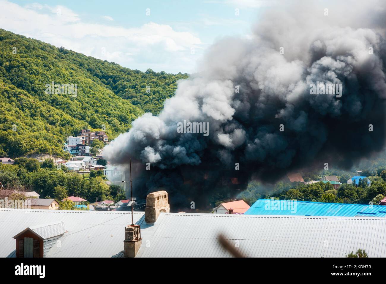 Fire in the village. Clouds of black smoke over a burning building. The ...