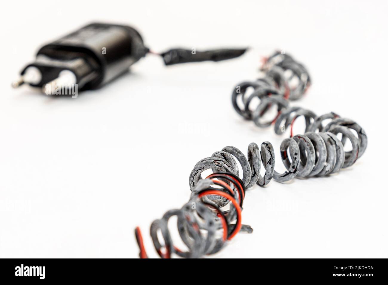 Charred charger wire, close-up. White background. Closeup. Short ...