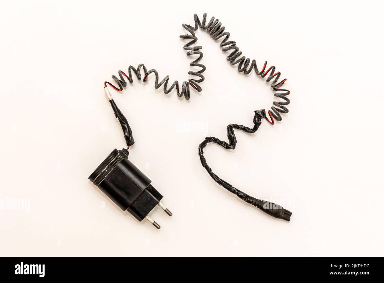 Charred charger wire, close-up. White background. Flat lay. Short ...