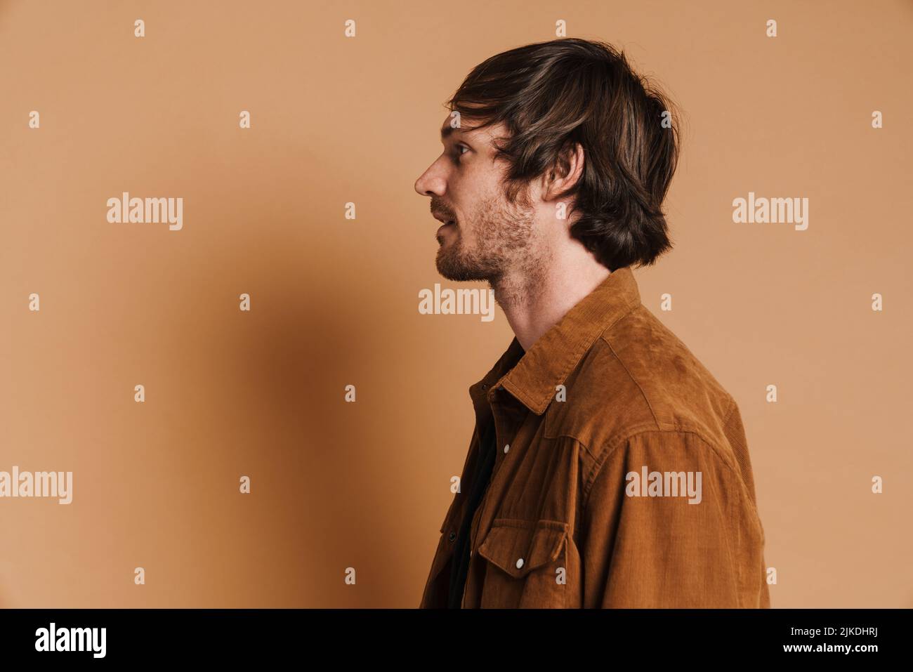 White unshaven man looking aside while posing in profile isolated over ...