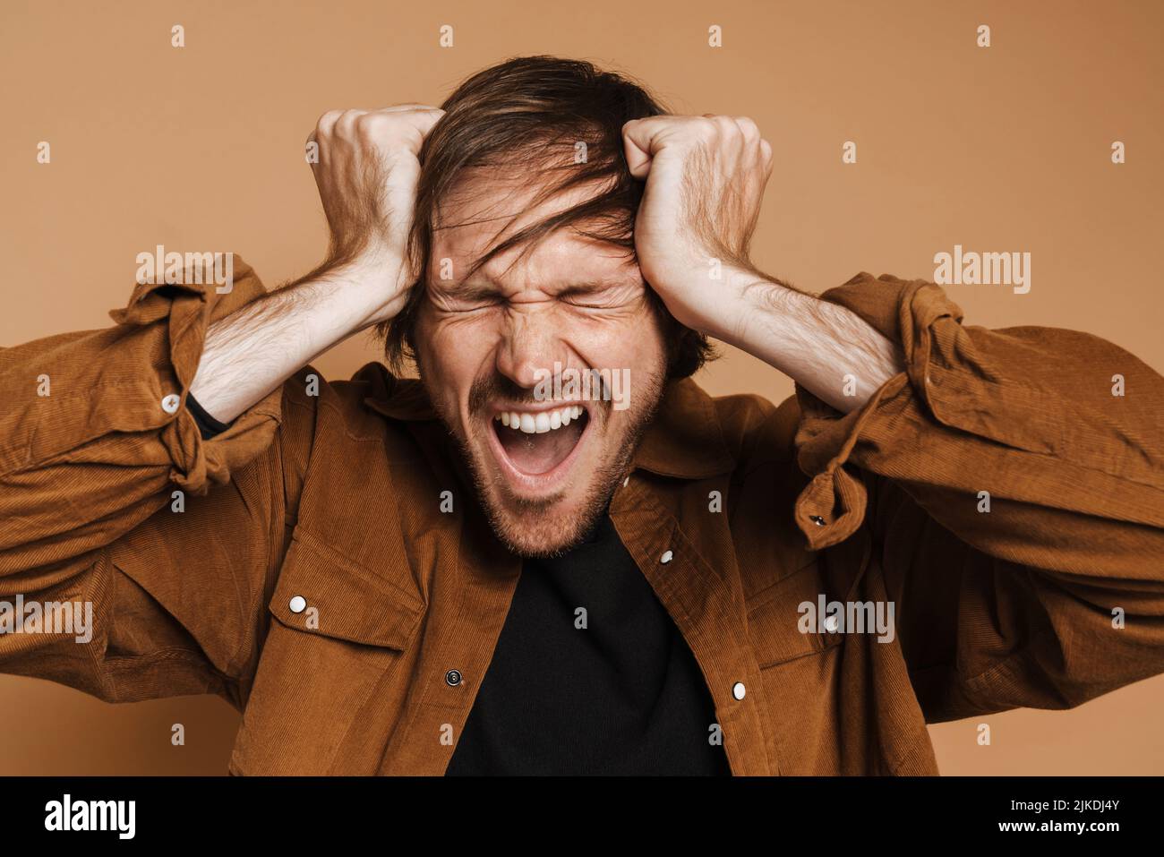 White man with headache holding his head and screaming isolated over ...