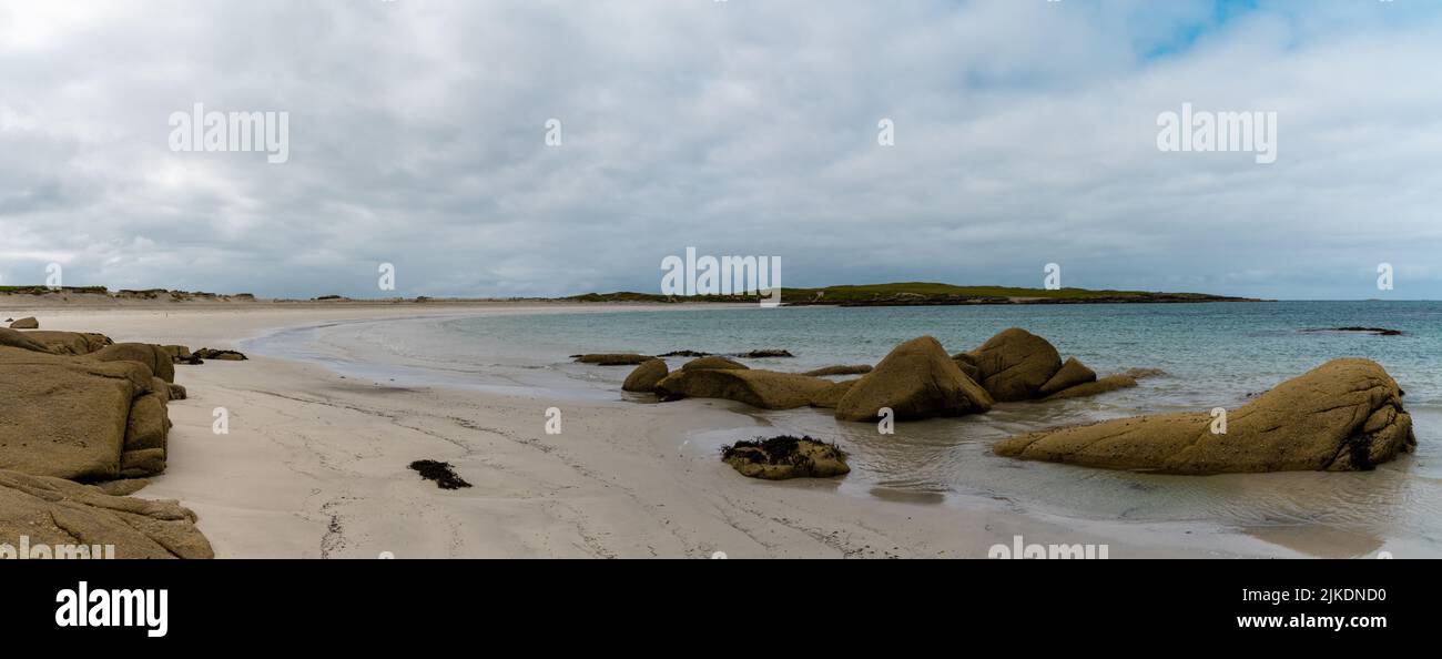 A panorama beach landscape of Dog's Bay with large granite boulders in ...