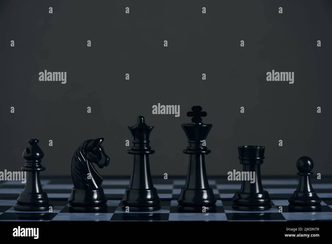 All suits black chess pieces on chess board Stock Photo - Alamy