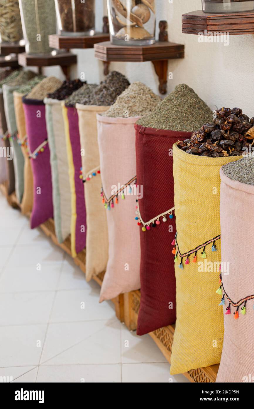 Arabian style bags with colourful raw ingredients in a row in a spices ...