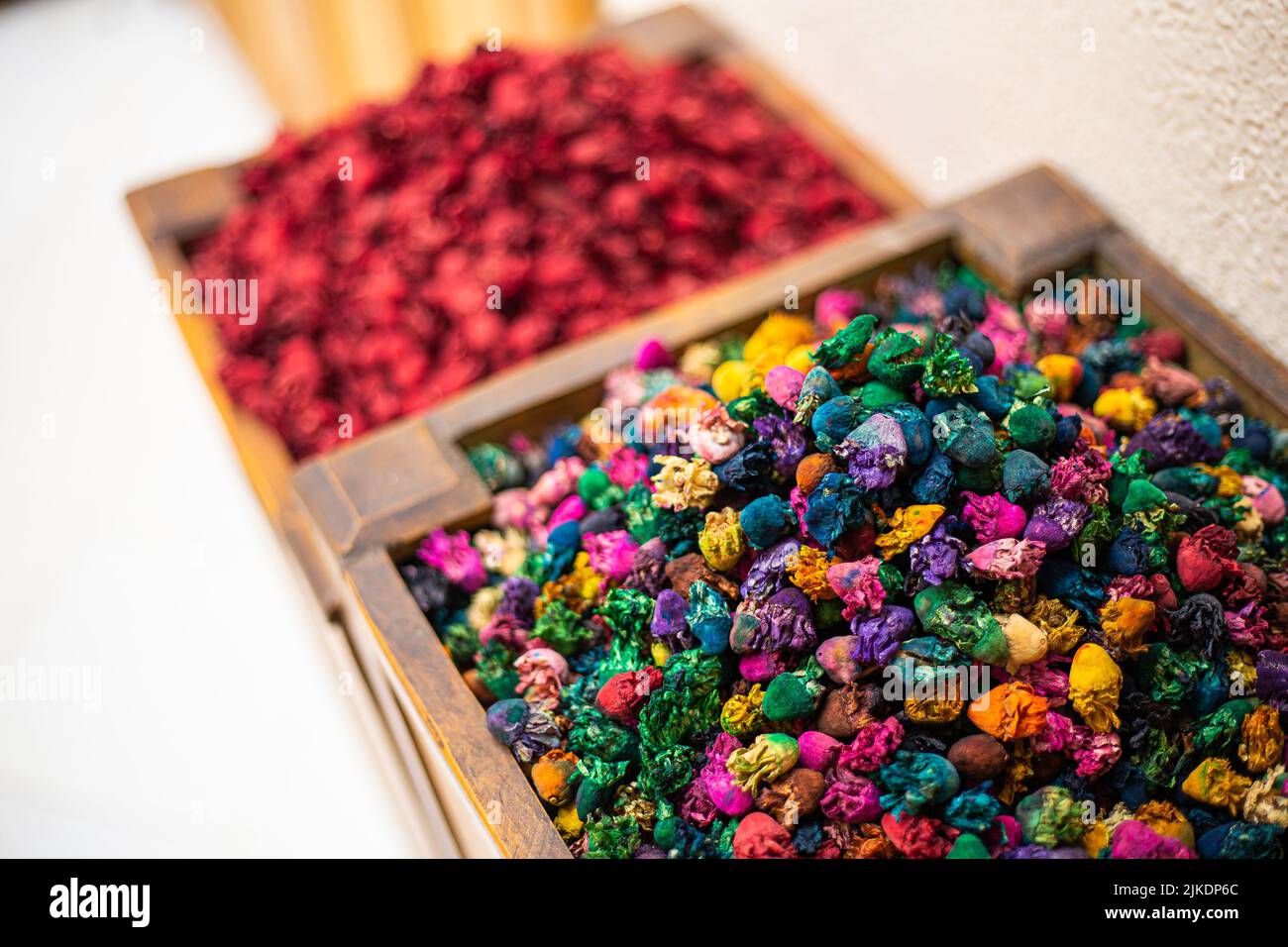 Purple brown and other colourful flower petal spices on wooden boxes on ...