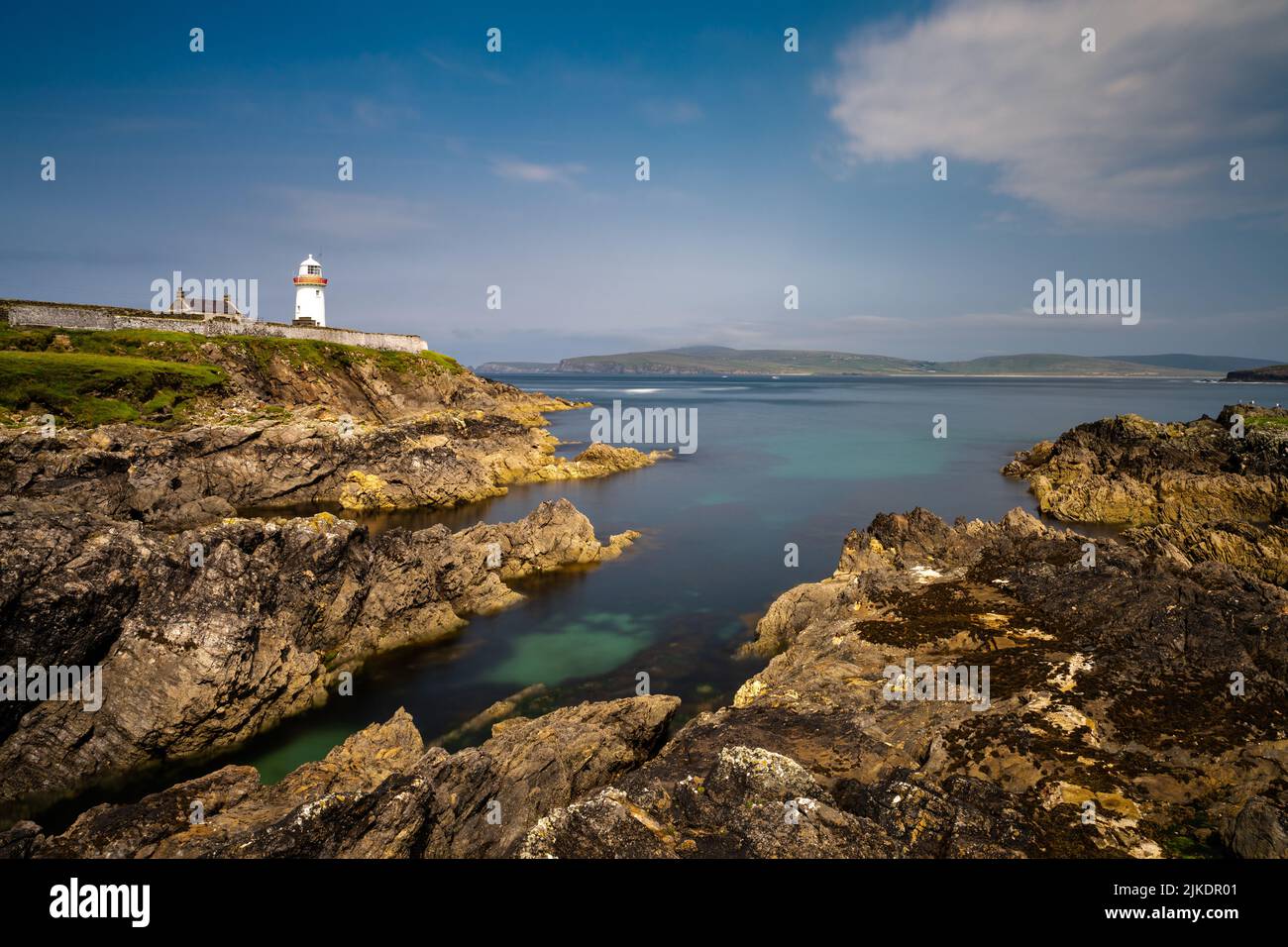 rocky shoreline with turquoise pools and the historic Broadhaven ...