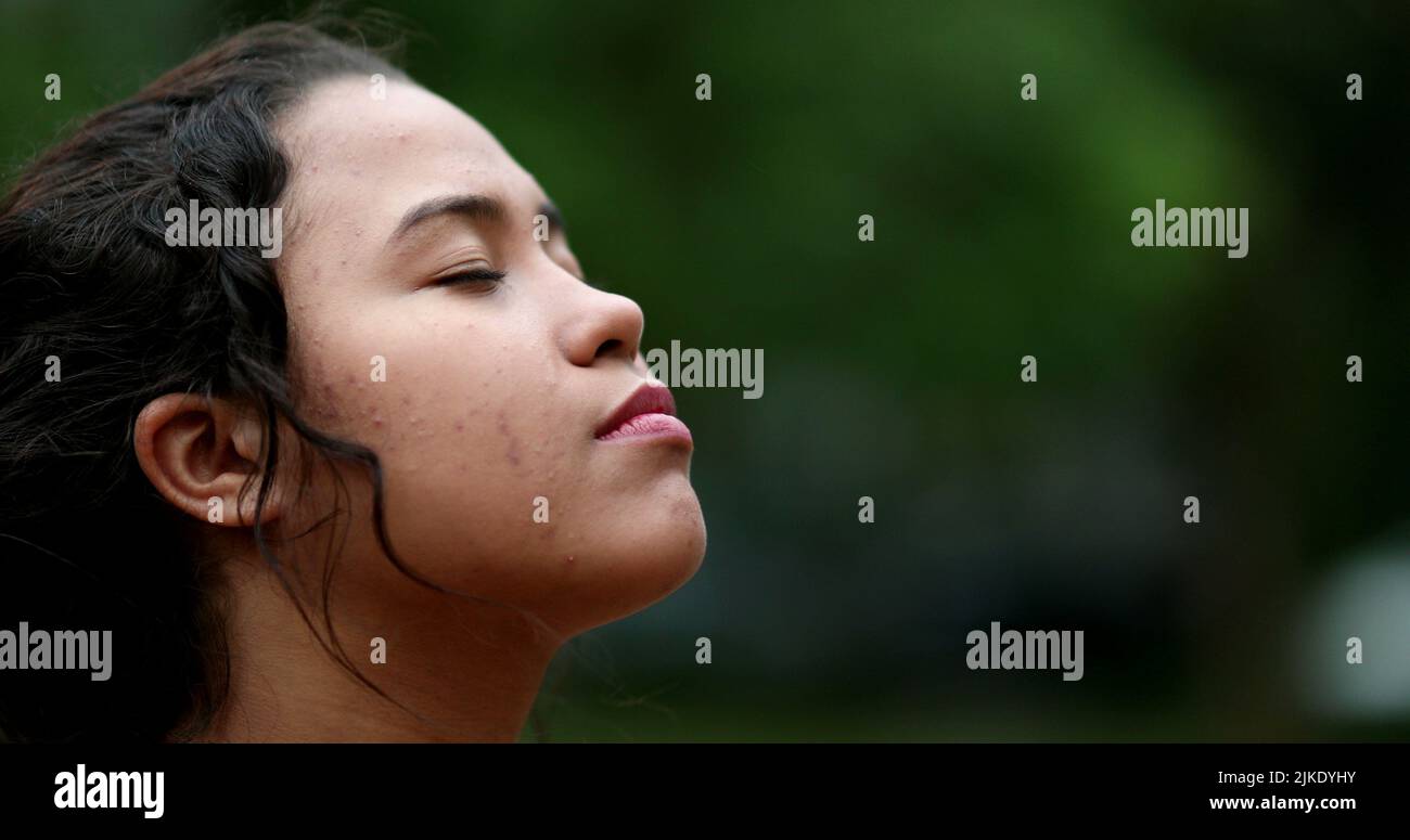 Young woman face opening eyes in meditation and contemplation loooking ...