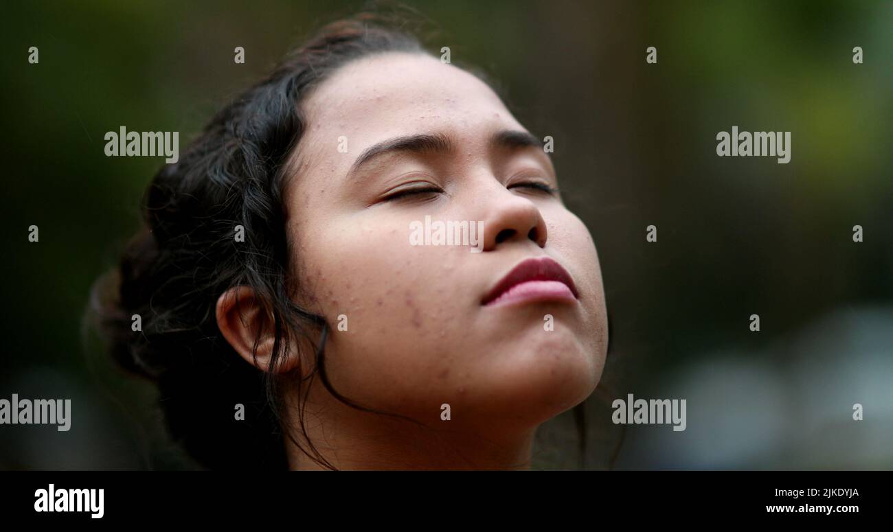 Young woman face opening eyes in meditation and contemplation loooking ...