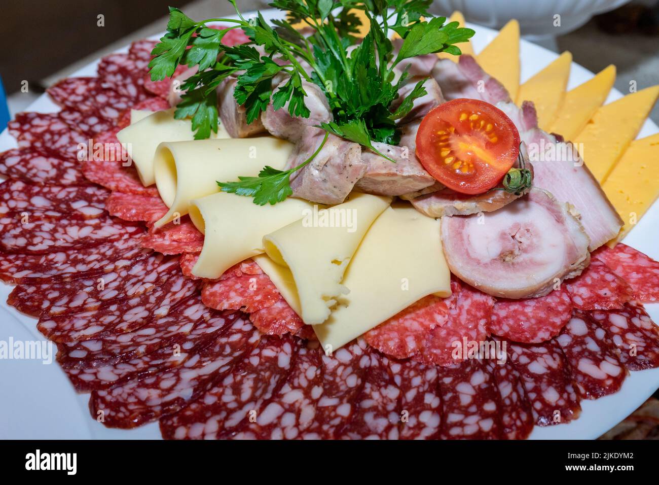 A plate of cold appetizers with various sausages, meat, and cheese ...