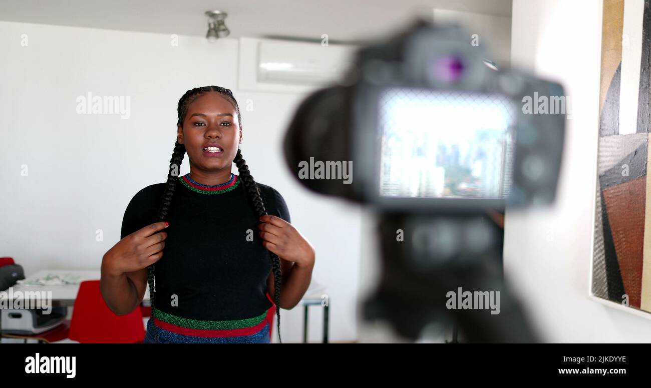 Young woman vlogging in front of camera tripod Stock Photo - Alamy