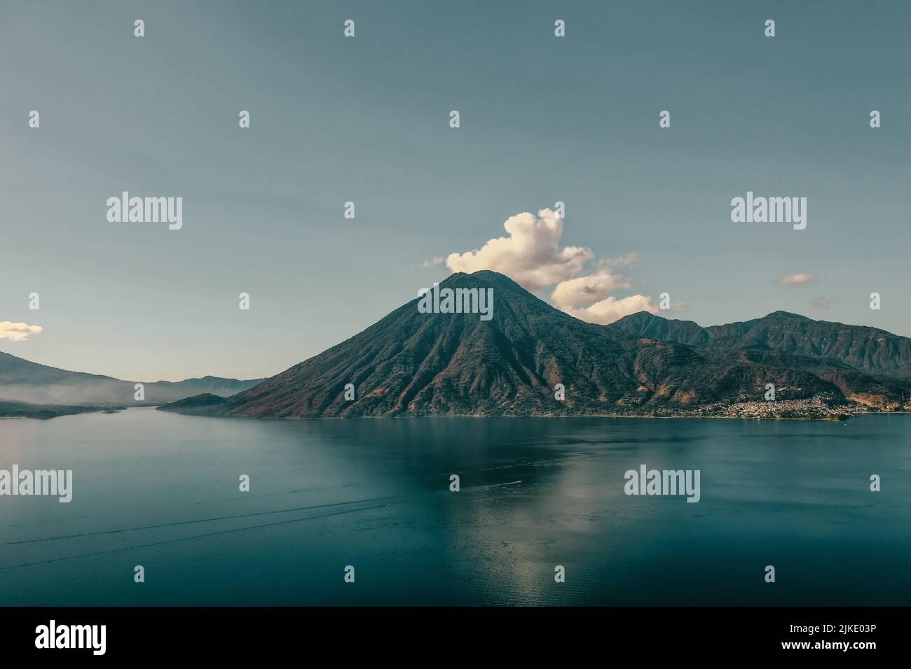 The beautiful landscape of Lake Atitlan with calm waters that reflect ...