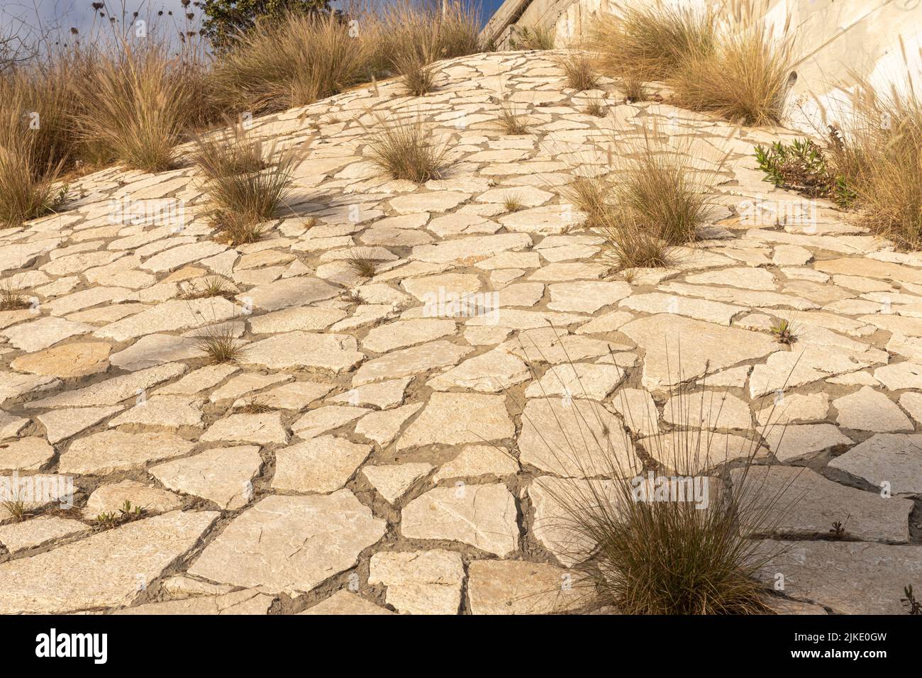 The bridge support lined with stones, overgrown with grass. Texture for ...