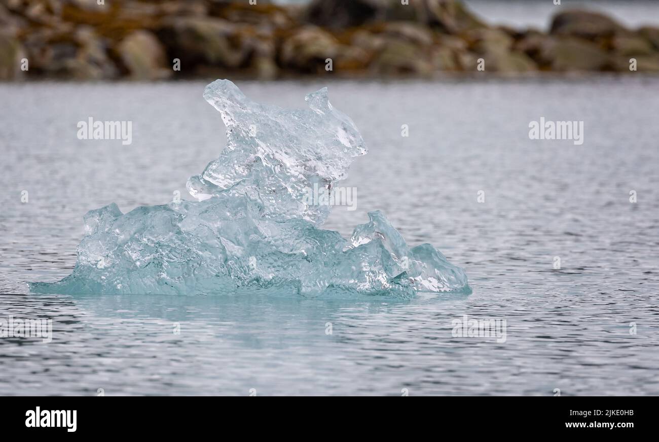 Close up of sparkling blue translucent icebergs in water of Kvanefjord ...