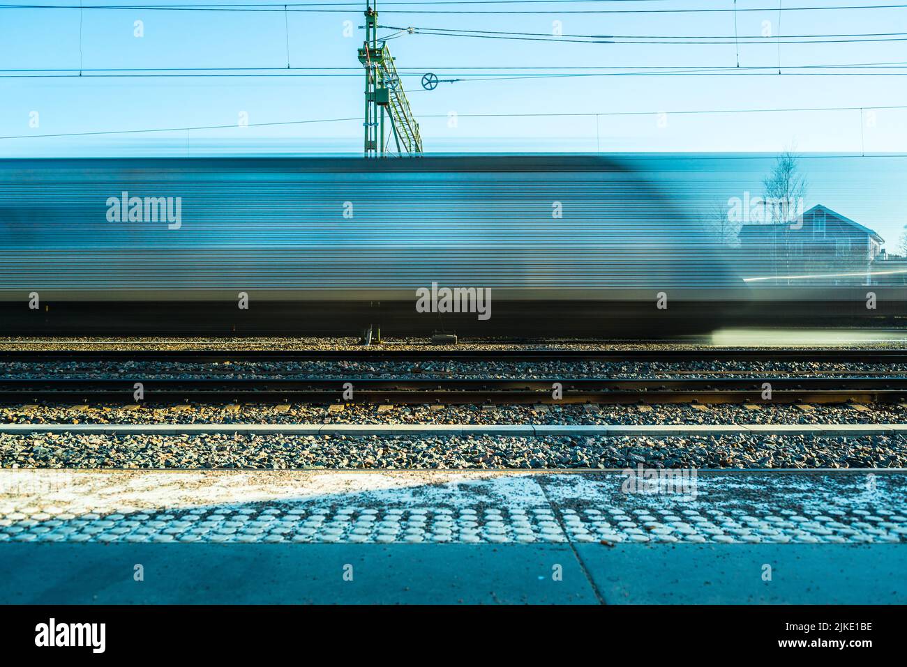 Fast passenger express train passing a station Stock Photo - Alamy