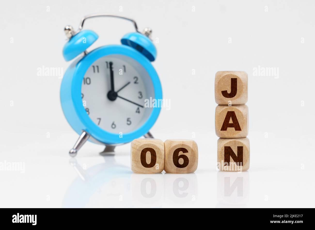 6st of January. Wooden cube calendar for January 6, next to a blue ...